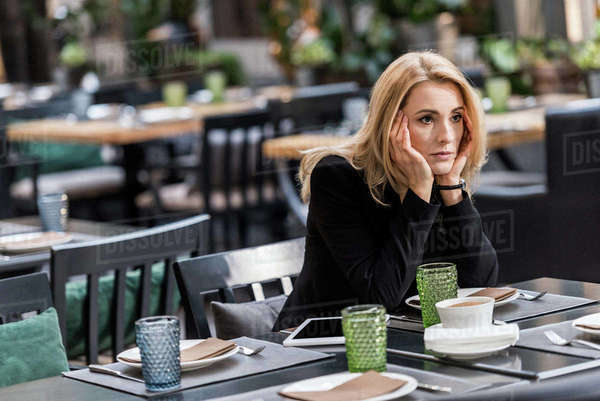 portrait of pensive woman waiting for someone in restaurant - Royalty ...