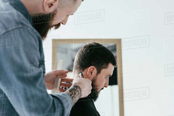 side view of barber shaving customer hair at barbershop isolated on ...