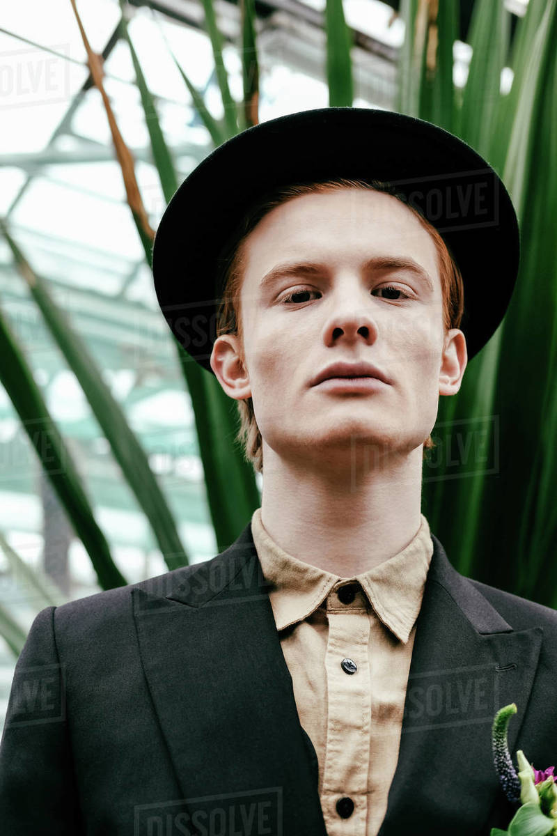 portrait of handsome red hair man in hat looking at camera in ...