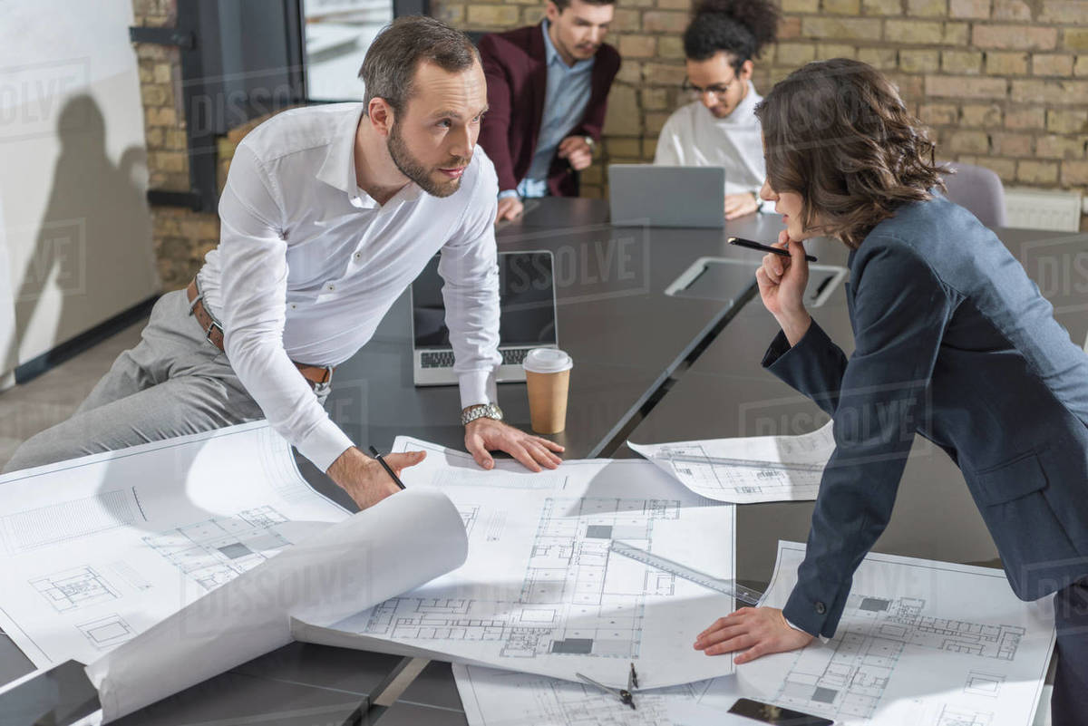Architects working together on building plans at office - Royalty-free ...