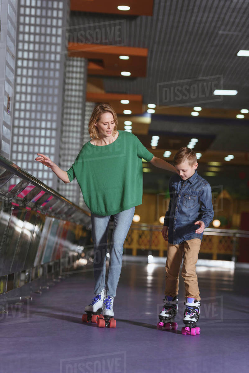 Mother and little son skating together on roller rink - Royalty-free ...