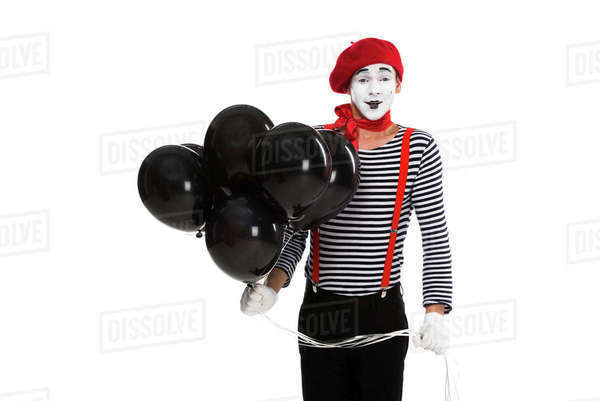 Cheerful mime holding bundle of balloons with helium isolated on white ...