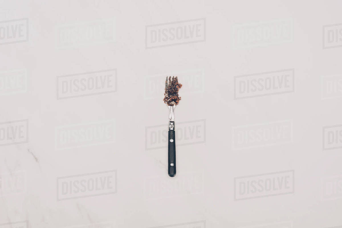 top view of fork with cake pieces isolated on grey - Stock Photo - Dissolve
