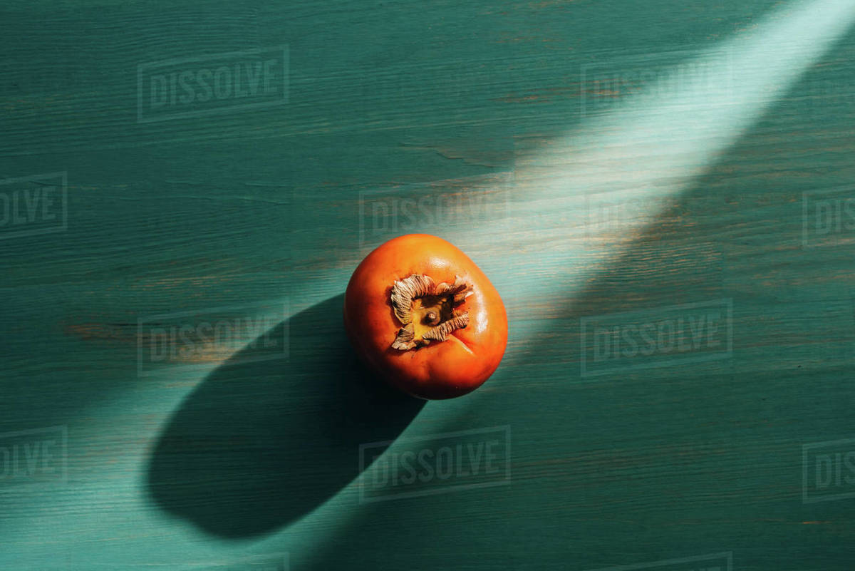 top view of persimmon on table with light and shadow - Royalty-free ...
