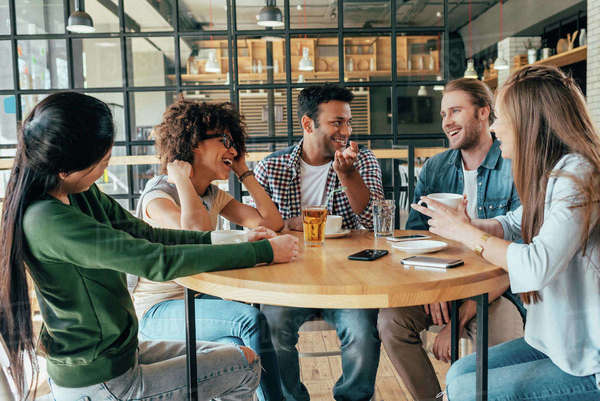 Group of young multiethnic friends spending good time together in cafe ...