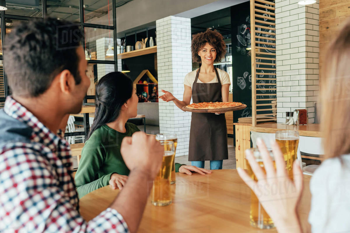 African american woman waitress bringing pizza for clients in cafe ...