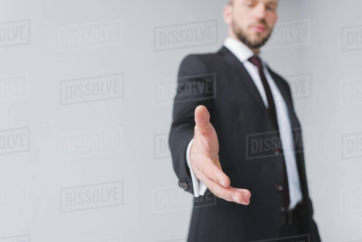 selective focus of businessman in suit with outstretched hand isolated ...