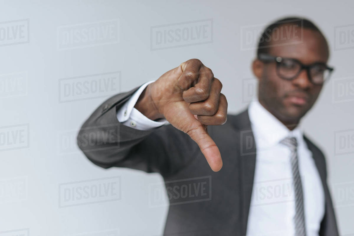selective focus of african american businessman showing thumb down ...