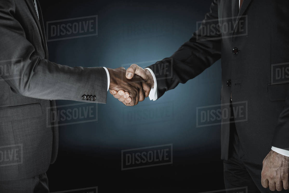 cropped shot of multicultural businessmen handshake isolated on black ...