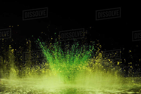 Yellow and green holi powder explosion on black, Hindu spring festival ...