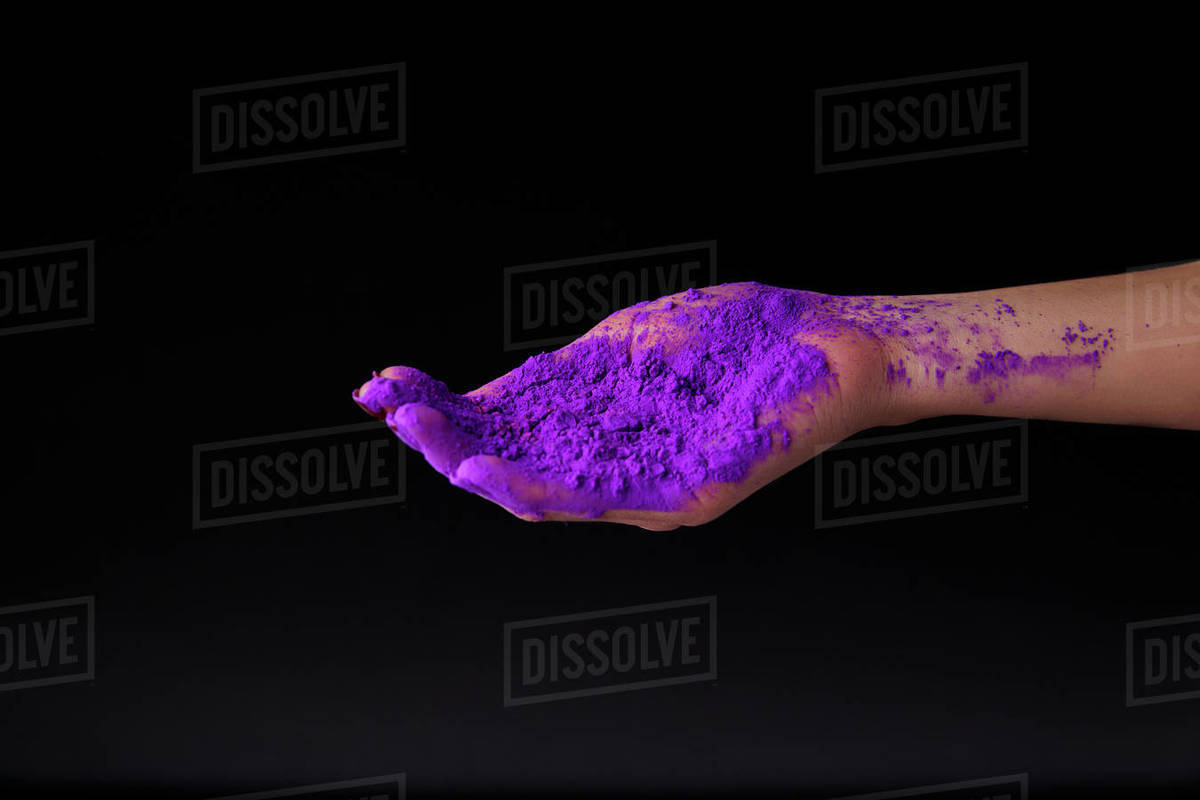 Cropped view of hand with purple holi powder, isolated on black - Stock ...