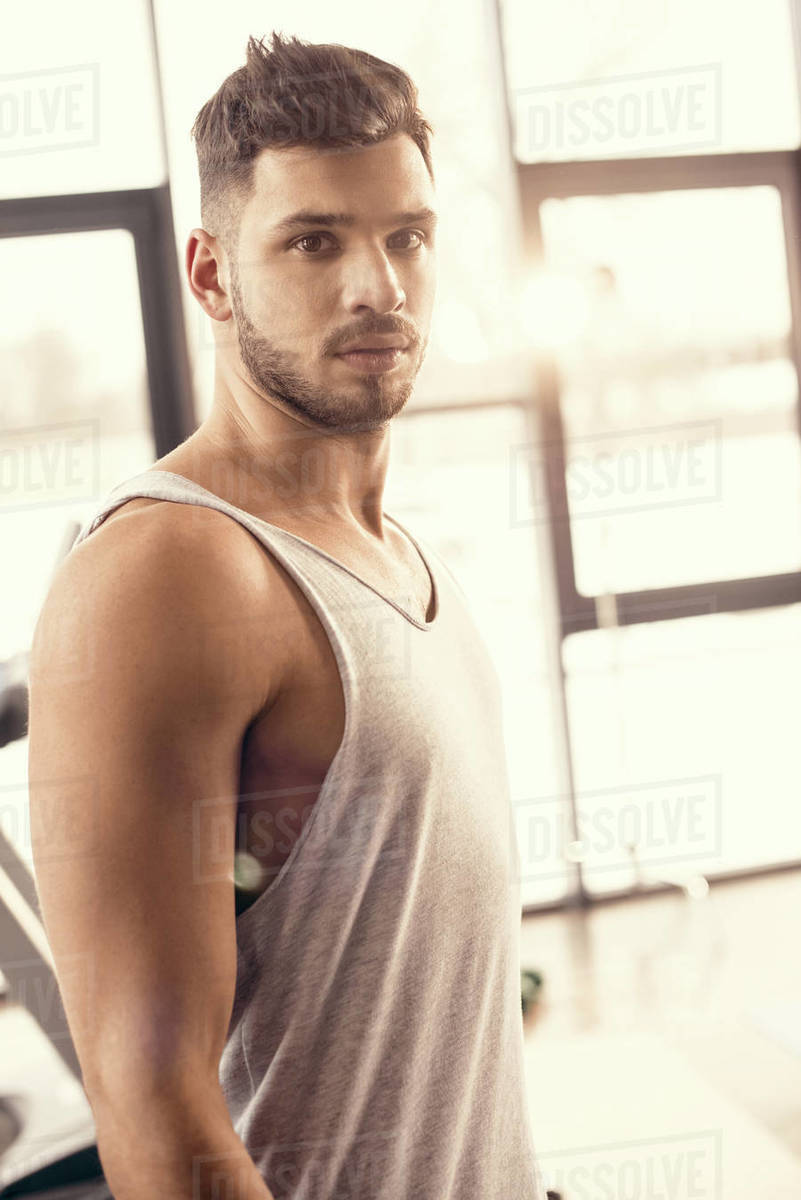 Portrait of handsome sportsman looking at camera in gym - Royalty-free ...