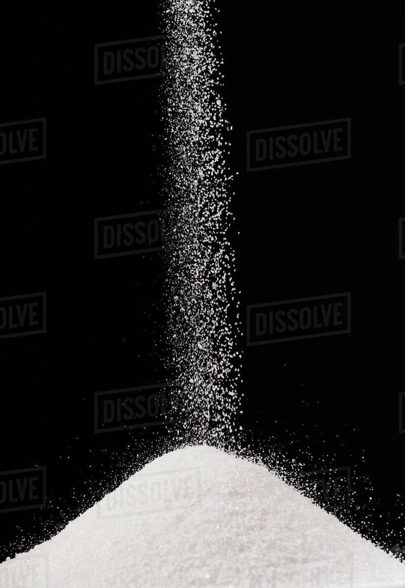 Sugar falling on pile isolated on black - Stock Photo - Dissolve