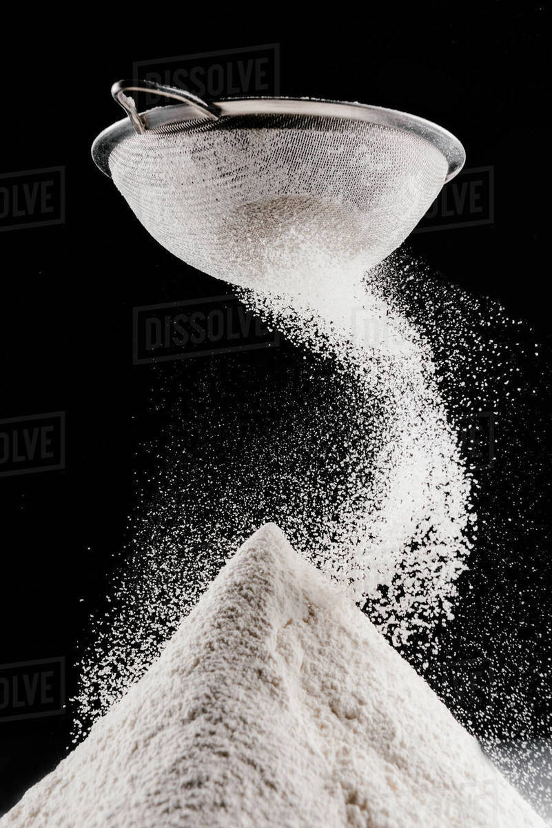 White flour falling from sieve on pile isolated on black - Royalty-free ...