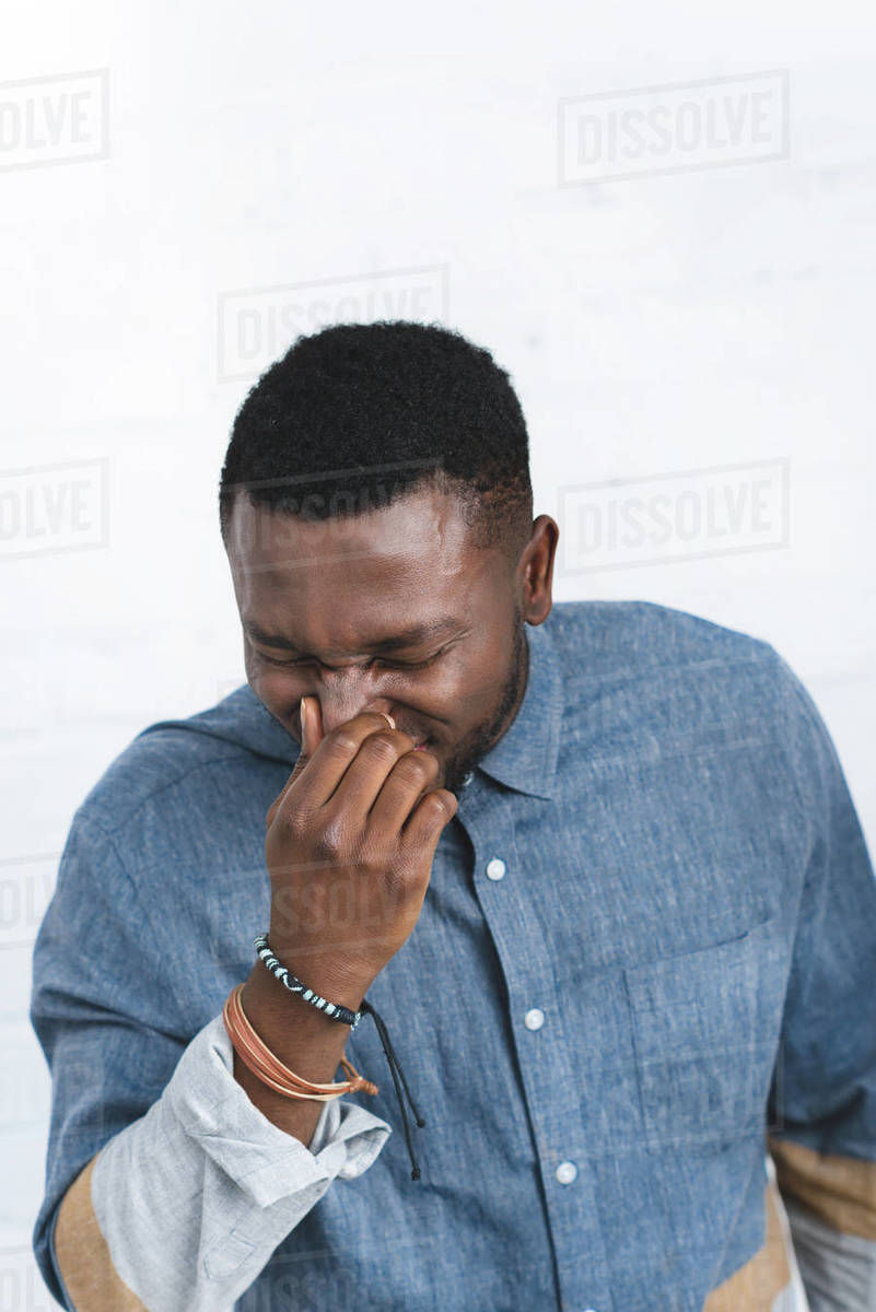Handsome African American man sneezing - Stock Photo - Dissolve