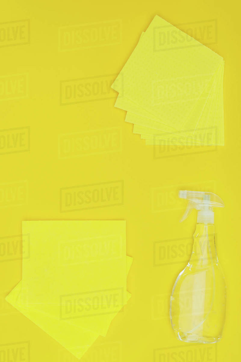 Top view of yellow rags and spray bottle isolated on yellow - Royalty ...