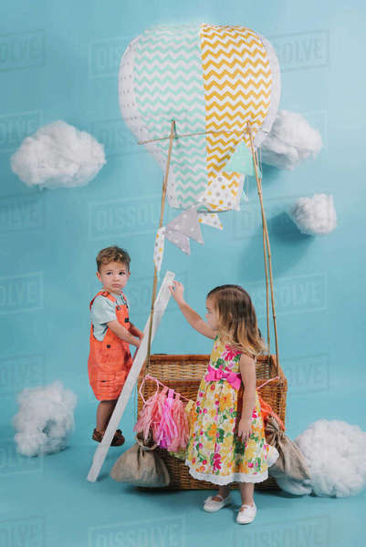Beautiful little kids pretending to fly on hot air balloon in cloudy ...