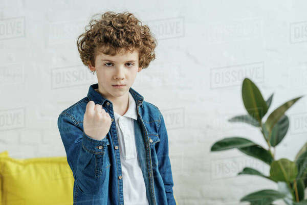 Angry child boy showing clenched fist - Stock Photo - Dissolve