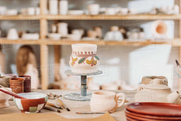 Traditional painted ceramic jug on table in pottery workshop - Royalty ...