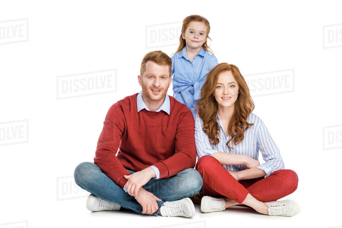 Happy redhead family with one child smiling at camera isolated on white ...