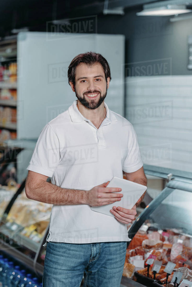 Portrait of smiling shop assistant with tablet in hypermarket - Royalty ...