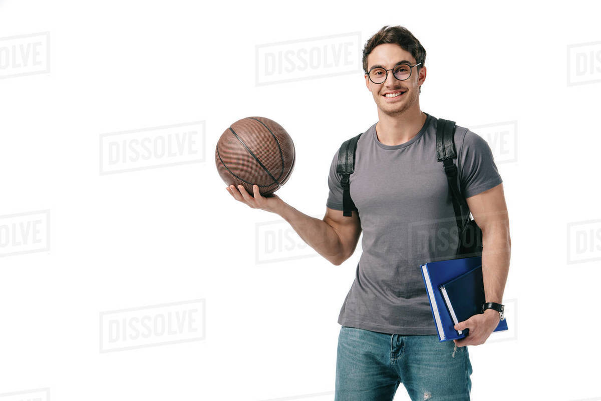 Smiling handsome student holding basketball ball isolated on white ...