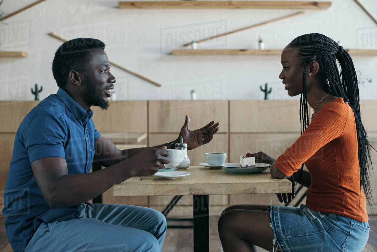 Side view of African American couple having conversation during date in ...