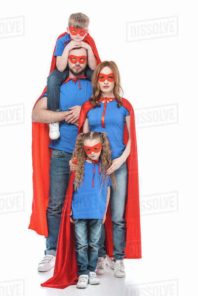 Full length view of family of superheroes looking at camera isolated on ...