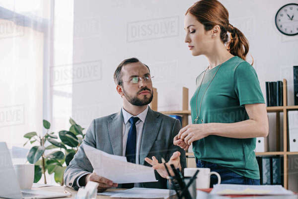 Businessman and client discussing contract during meeting in office ...