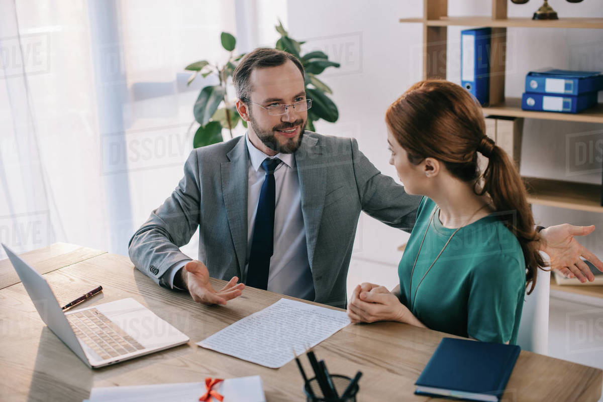 Businessman and client discussing contract during meeting in office ...
