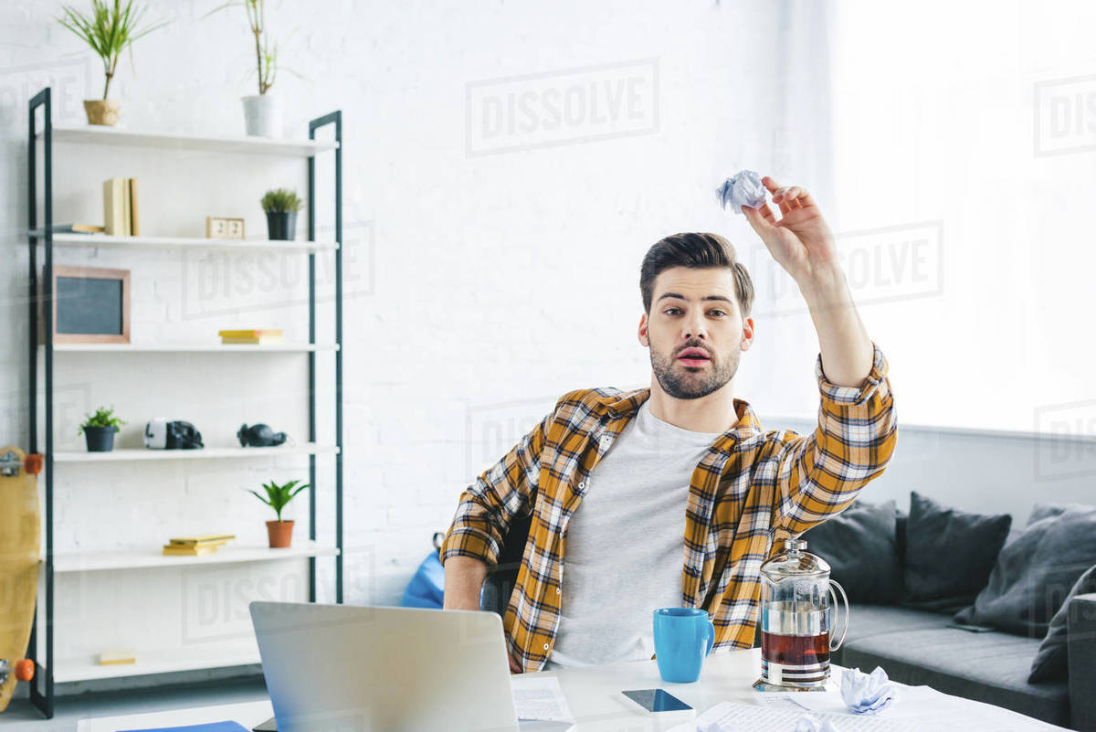 Man throwing crumpled paper while working at home office - Stock Photo ...