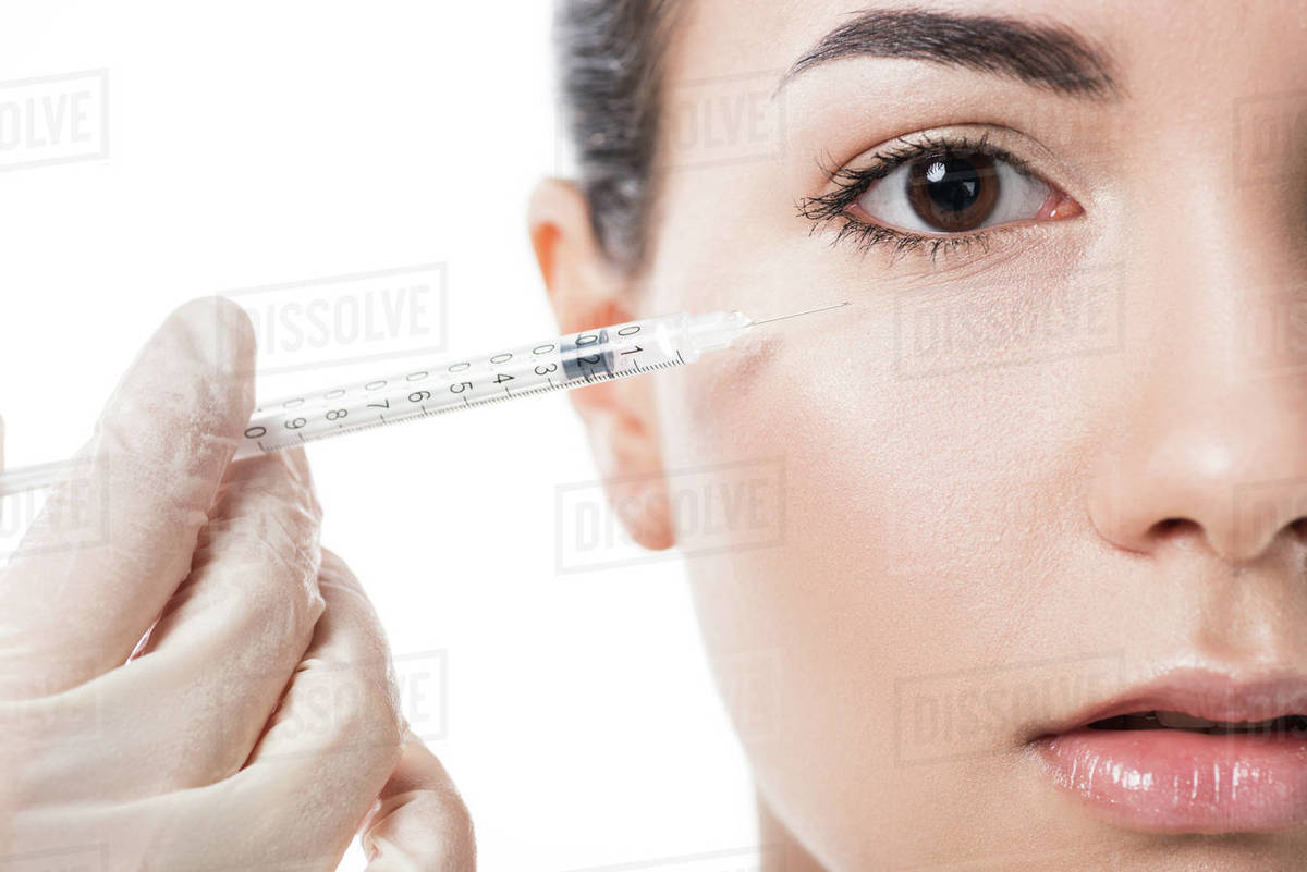 Cropped image of cosmetologist making beauty injection to girl with ...