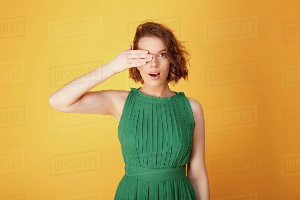 Obscured view of attractive woman covering one eye with hand isolated ...