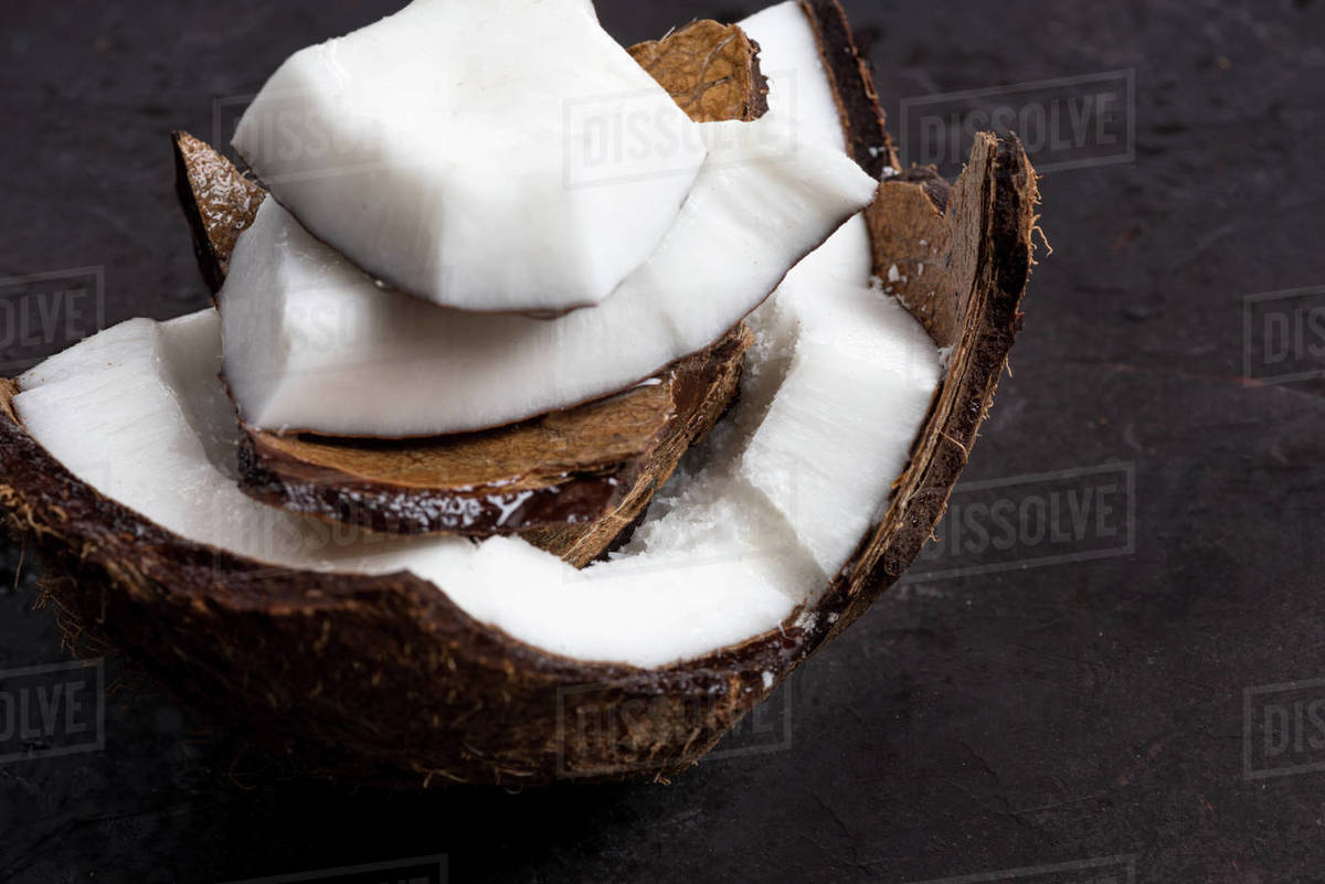 Close up of pieces of ripe tropical coconut on dark background - Stock ...