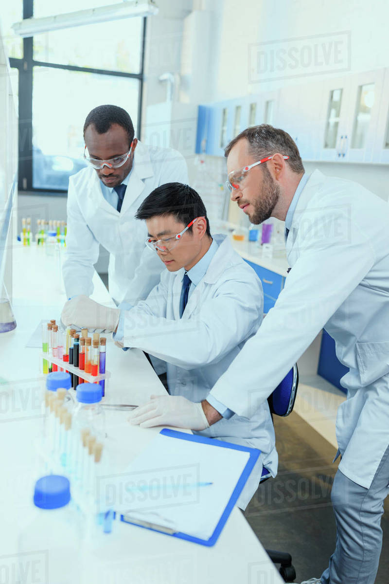 Professional scientists in white coats working together in chemical ...