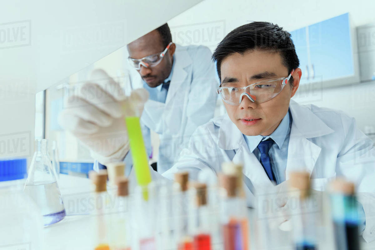 Professional scientists in white coats working together in chemical ...