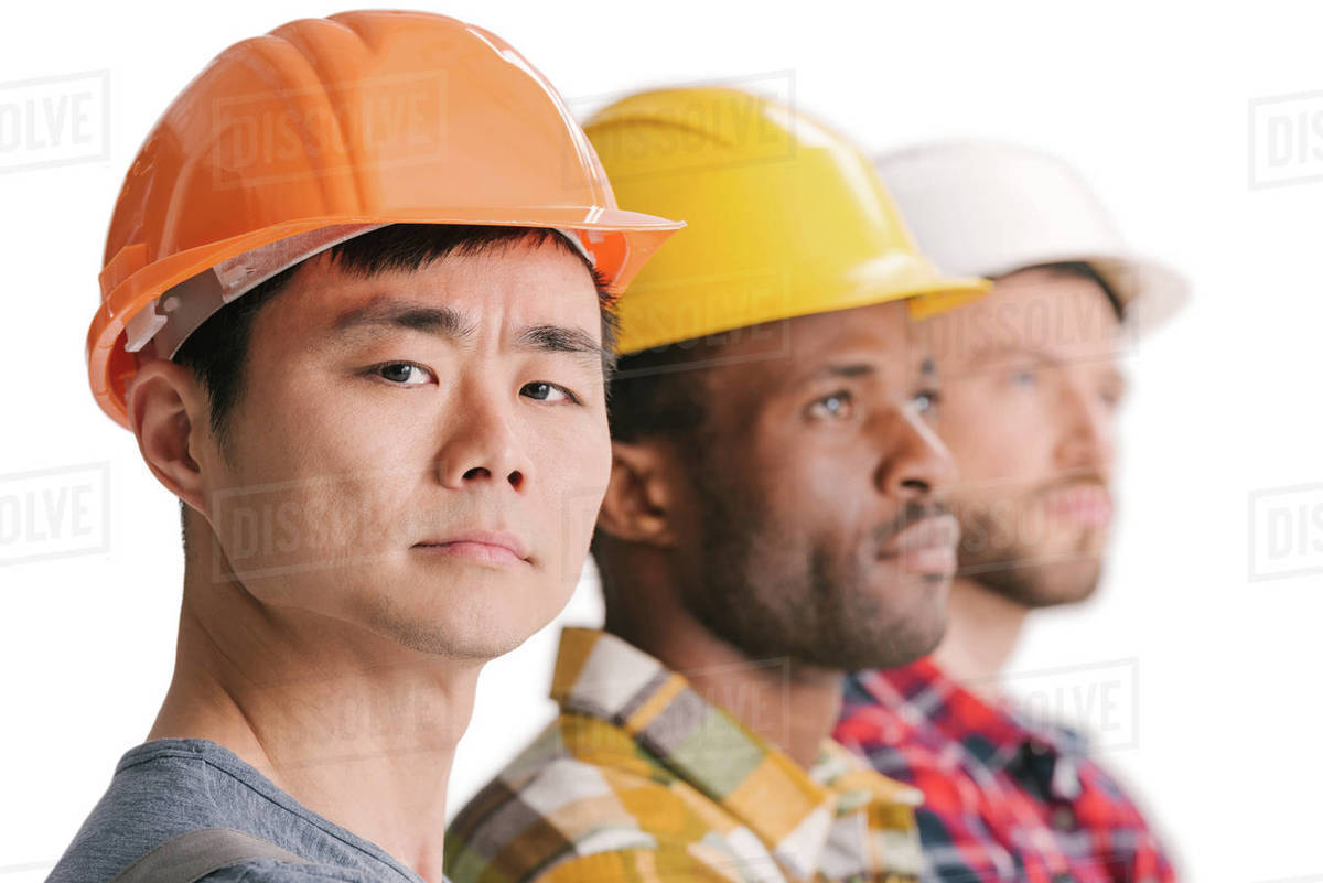 Side view of group of multiethnic construction workers in row - Royalty ...