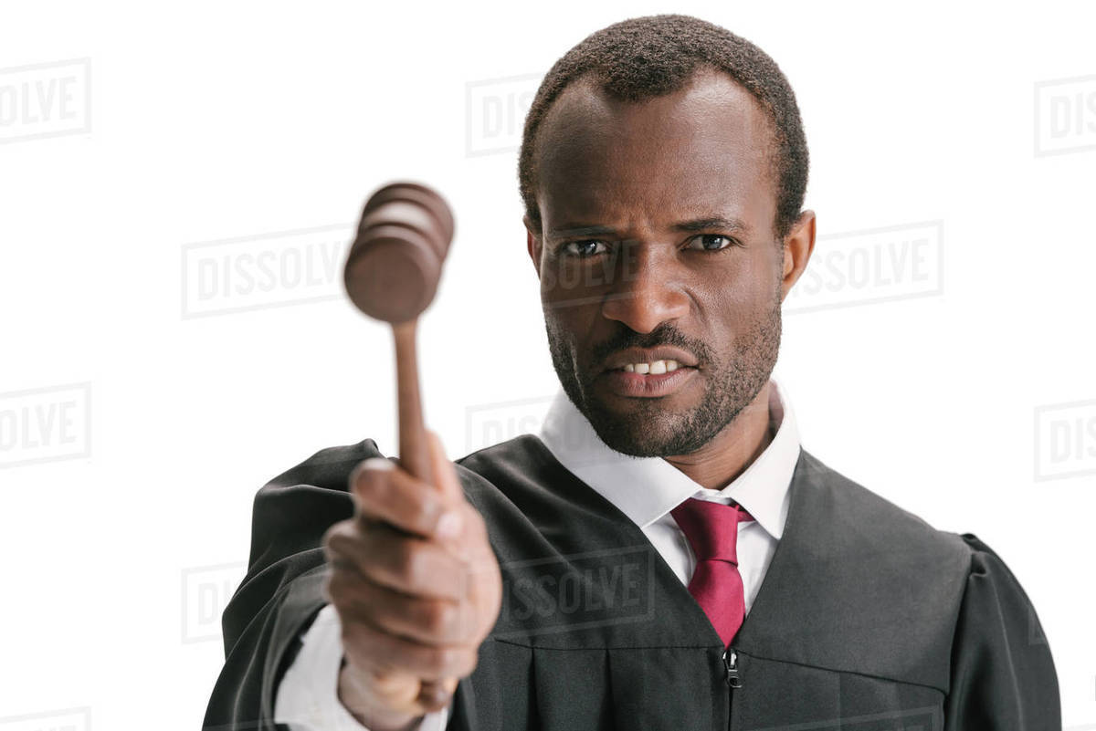 Critical judge pointing at camera with gavel isolated on white ...