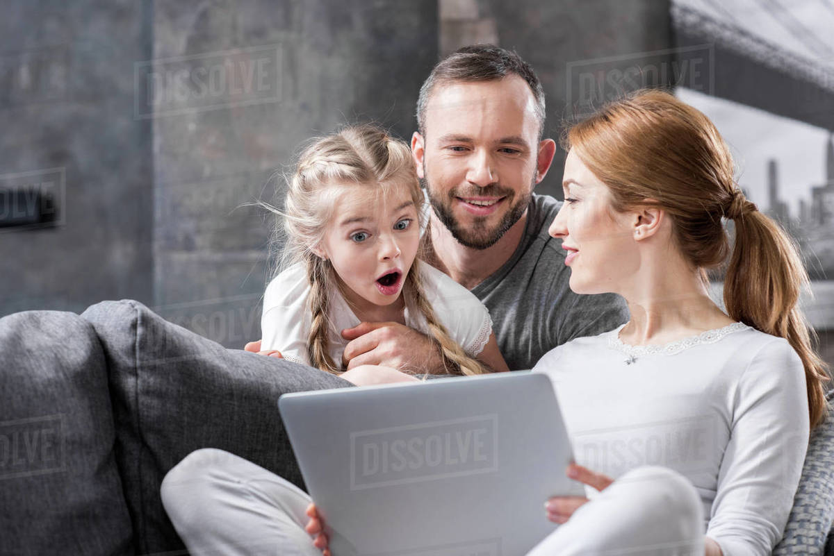 Excited young family using laptop together at home - Royalty-free Stock ...