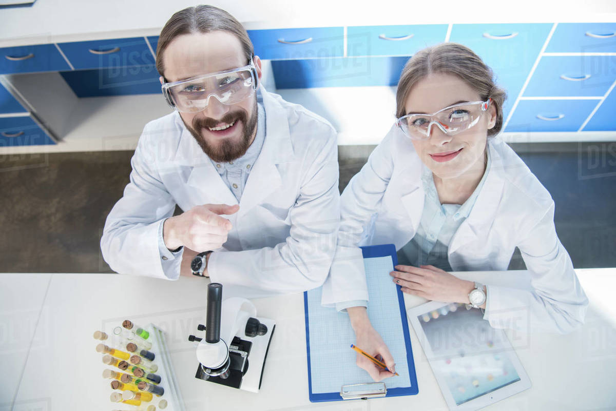 Young professional scientists working in laboratory and smiling at ...