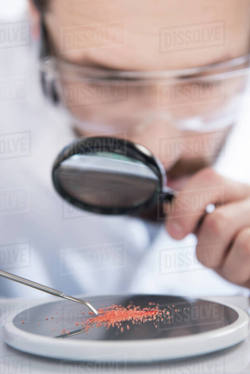 Close-up view of scientist looking at chemical sample through ...