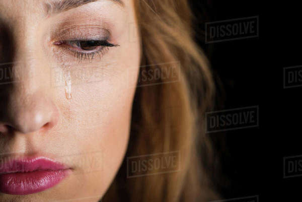Close-up view of young crying woman's face isolated on black - Royalty ...