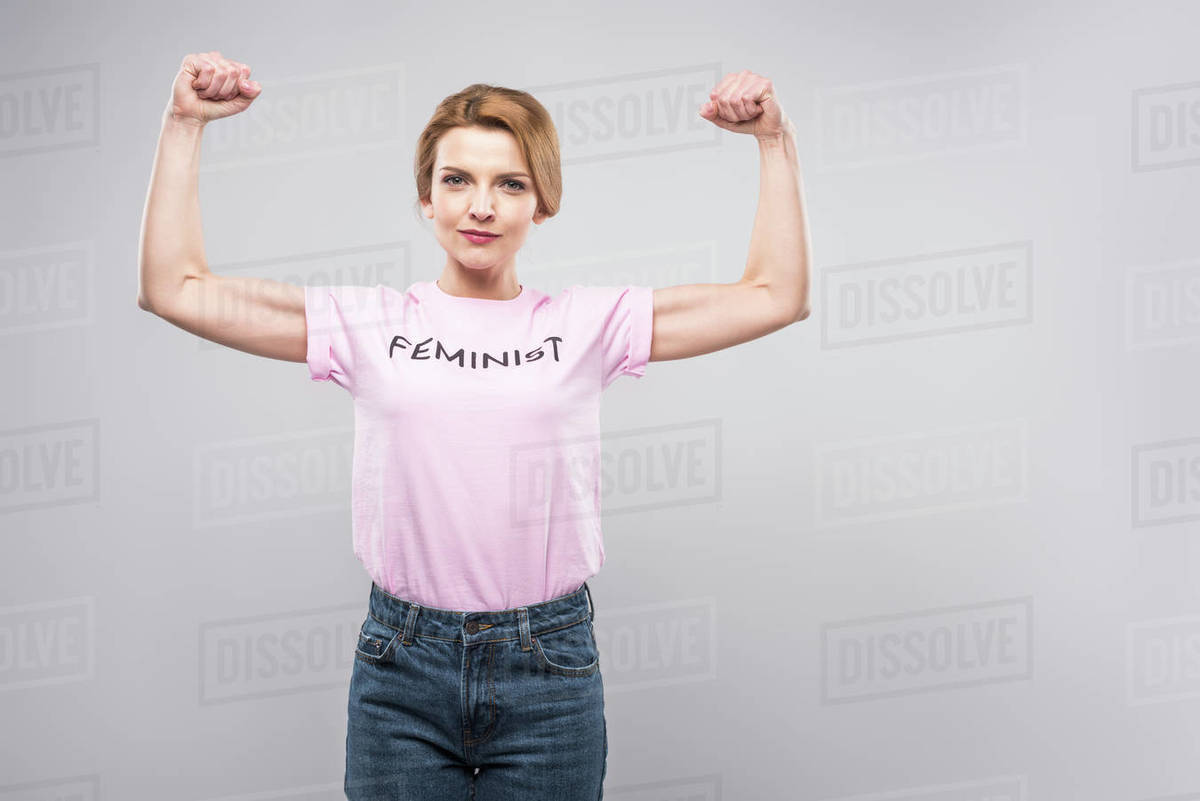 Strong woman in pink feminist t-shirt showing muscles on arms, isolated ...