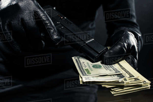 Close-up view of gun and dollars in hands of robber - Royalty-free ...