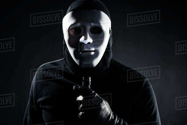 Robber in white mask holding flashlight - Stock Photo - Dissolve