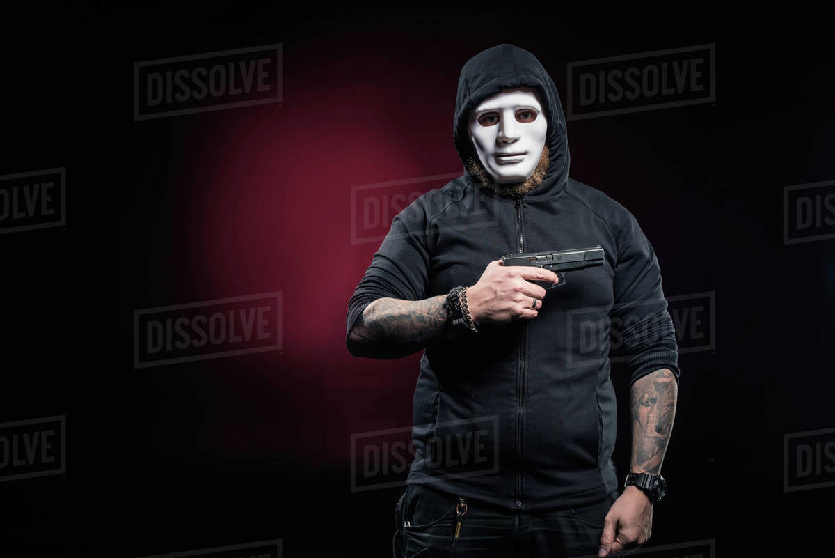 Robber in mask and balaclava holding gun - Stock Photo - Dissolve