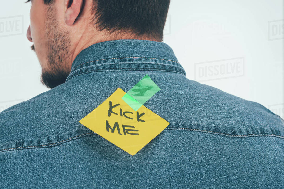 Back view of man with note on sticky tape with kick me lettering on ...
