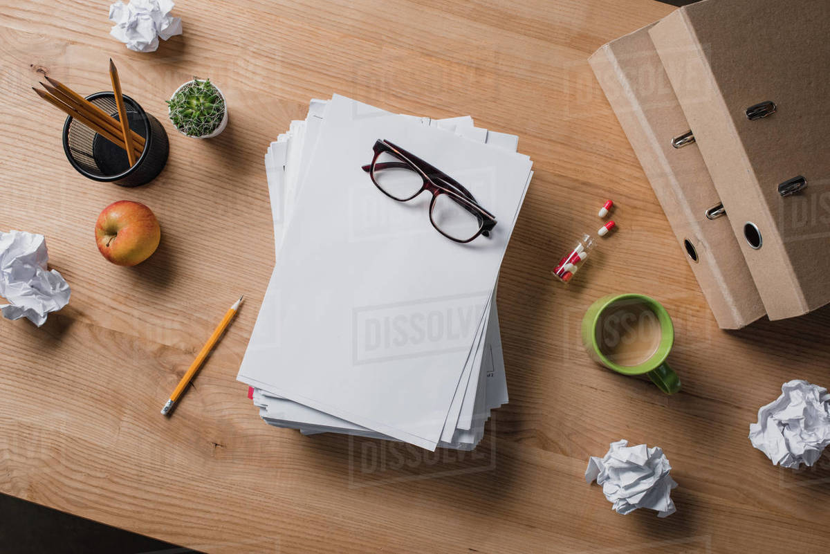 Top view of stacked blank papers with eyeglasses on top on wooden table ...