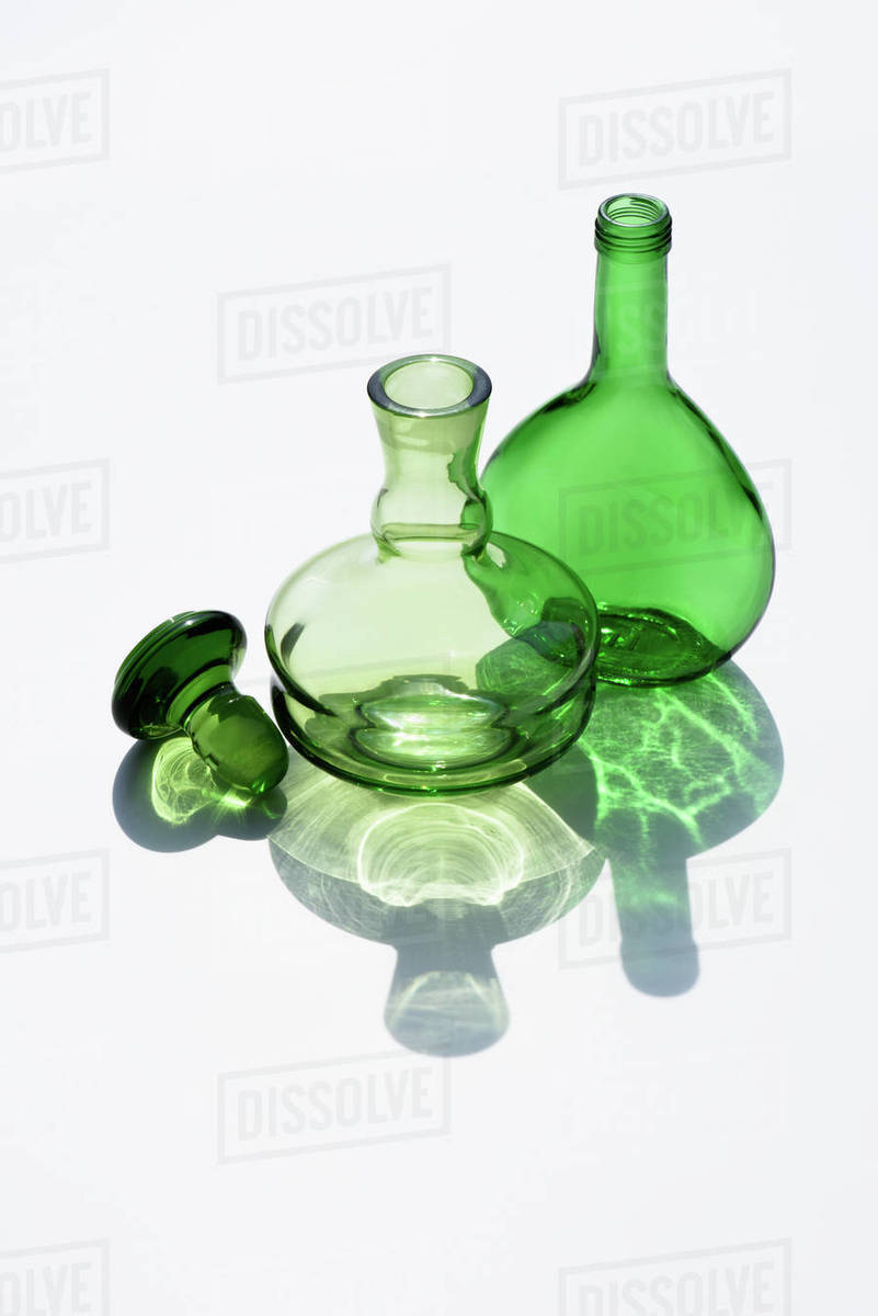 Close up view of empty glass bottles and cork on white backdrop ...