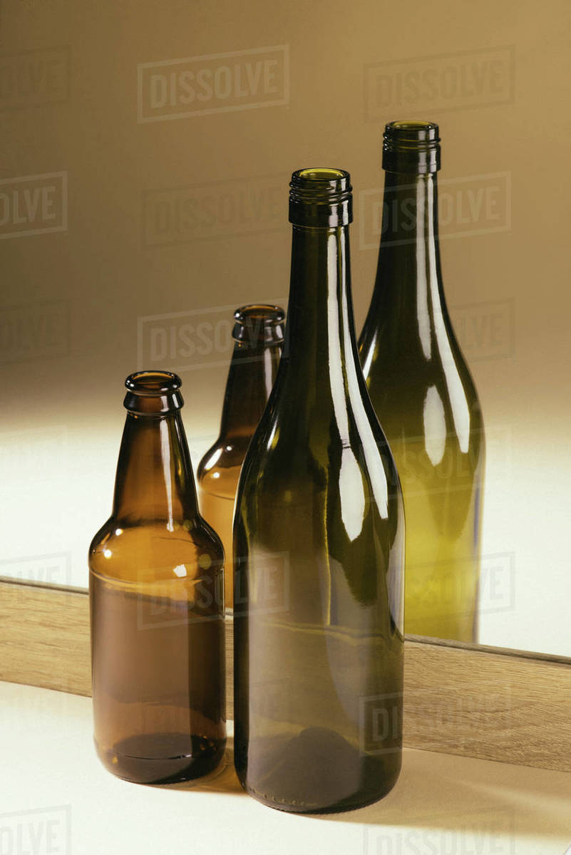 Close up view of empty glass bottles reflection in mirror - Royalty ...